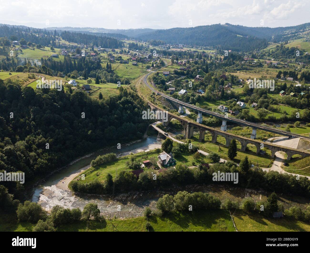 Aerial to old viaduct railway crossing in Vorokhta village, Ukraine ...