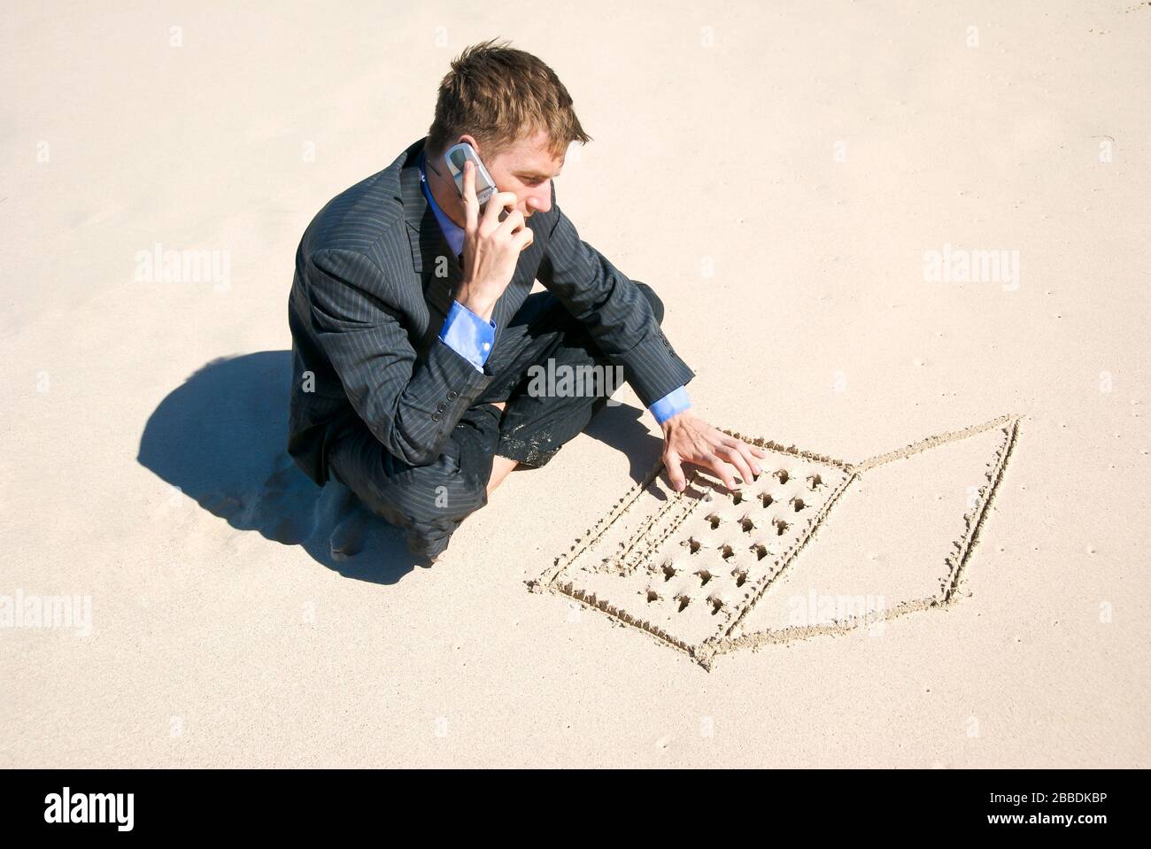 Telecommuting businessman multitasking between talking on his mobile ...