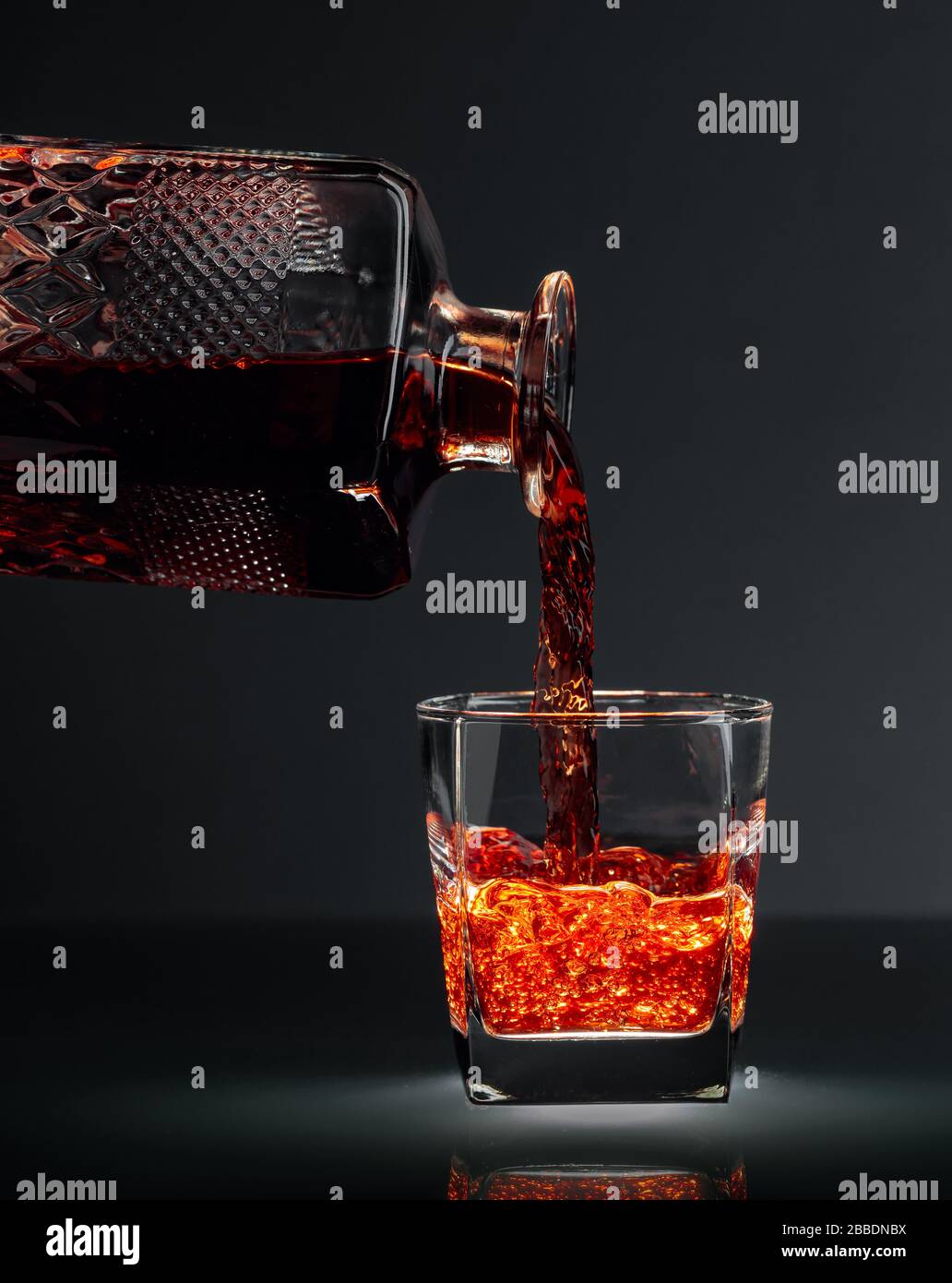 Whiskey pouring from a decanter into a glass Stock Photo - Alamy