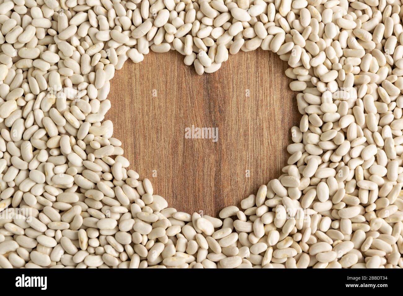 White raw aw beans background with wooden heart shape for space for ...
