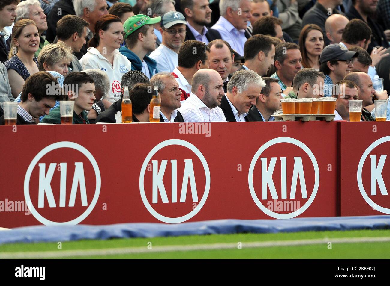 Spectators in the stands line their drinks up on the advertising boards ...