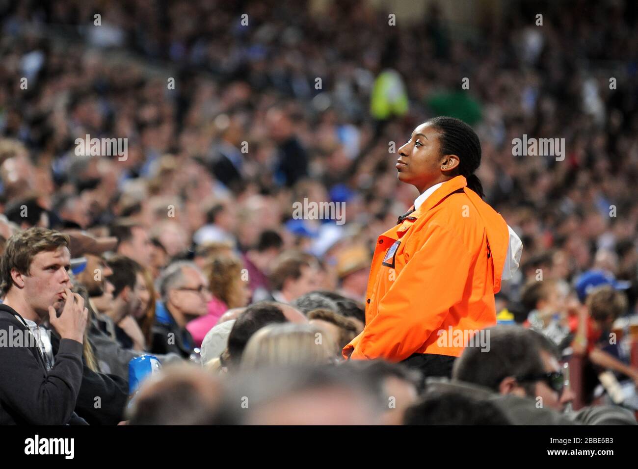 A steward on duty watching the crowd Stock Photo - Alamy