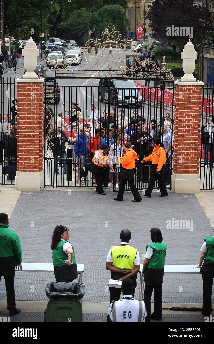 Stewards open the gates to let the crowd of spectators into the ground ...