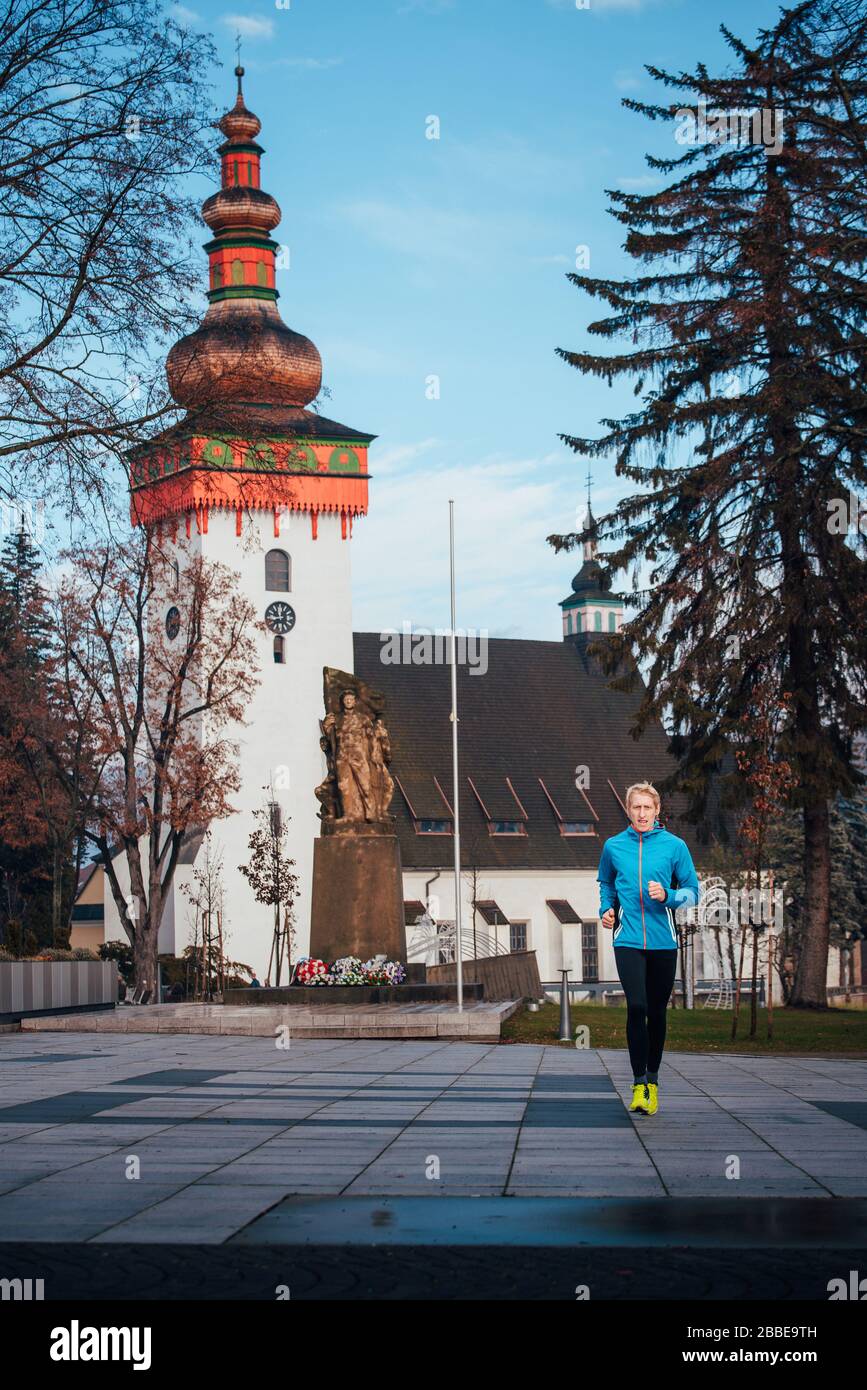 Man running in the city, church in background Stock Photo - Alamy