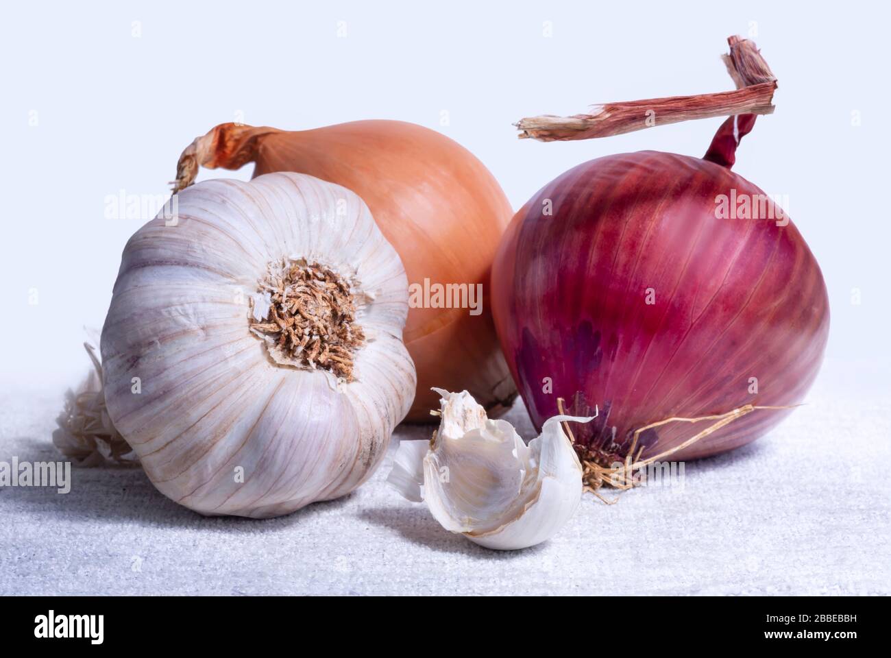 Multi colored bulb onions and a white head of garlic close-up on a ...