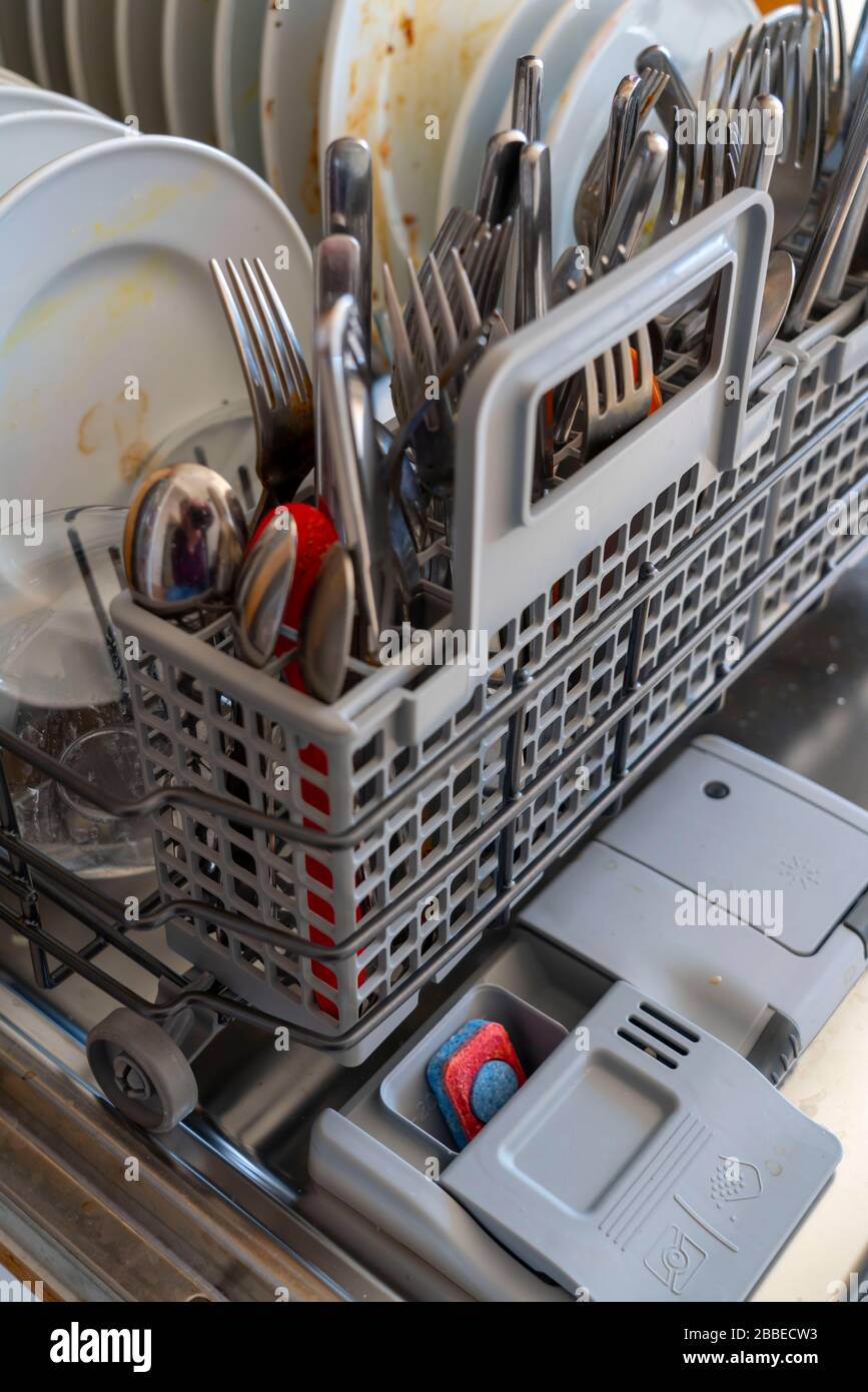 Dishwasher, full of dirty dishes, cleaning rod Stock Photo - Alamy