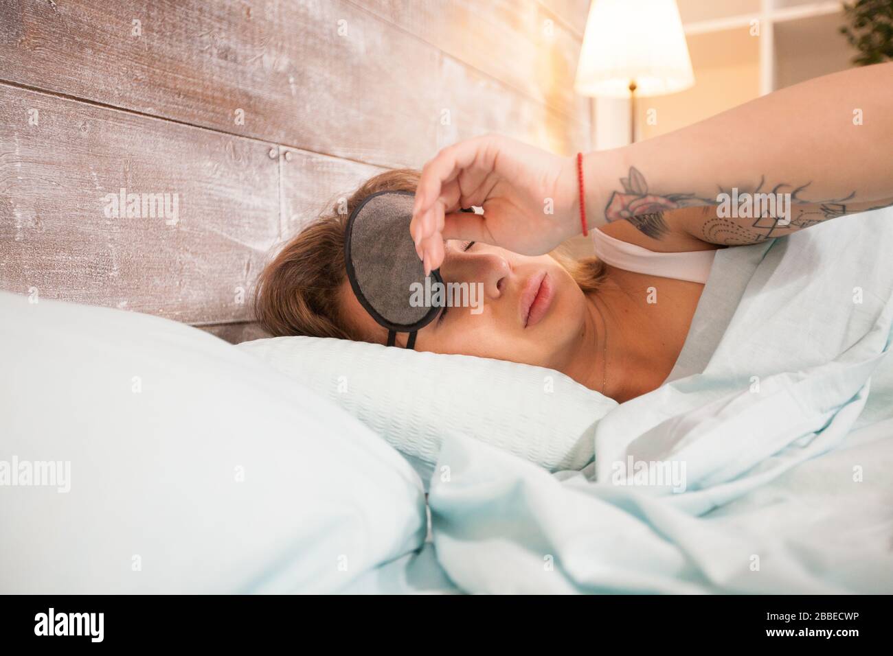 Beautiful young woman pulling her mask cover over the eyes Stock Photo ...