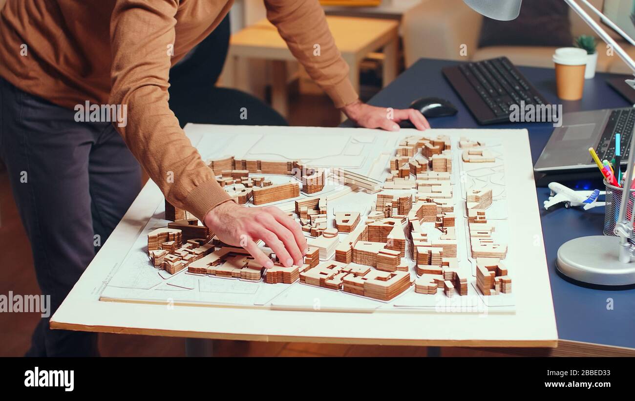 Male architect working on construction of a new city. Building models ...