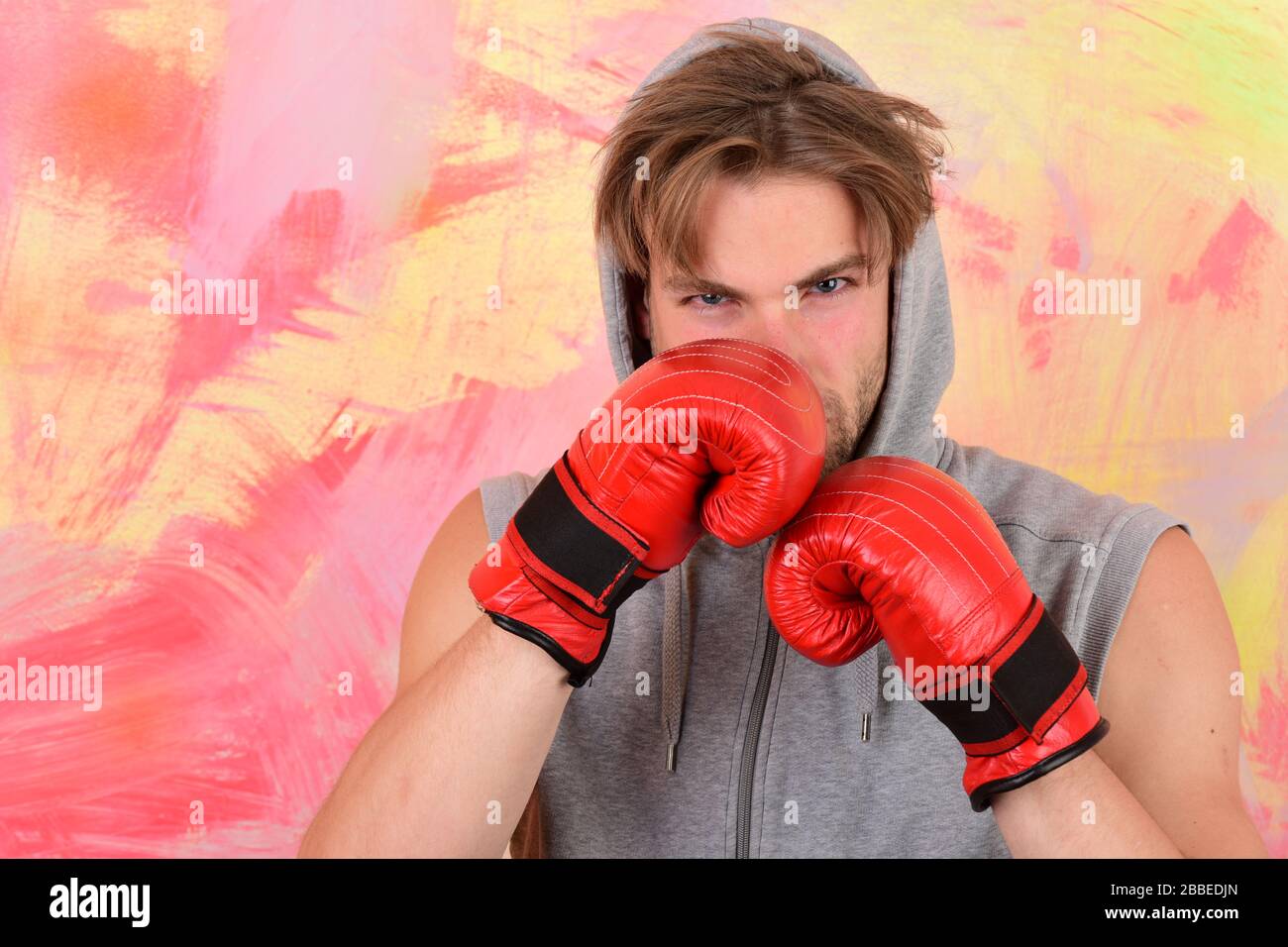 Boxer with concentrated face trains. Man with messy hair on colorful ...