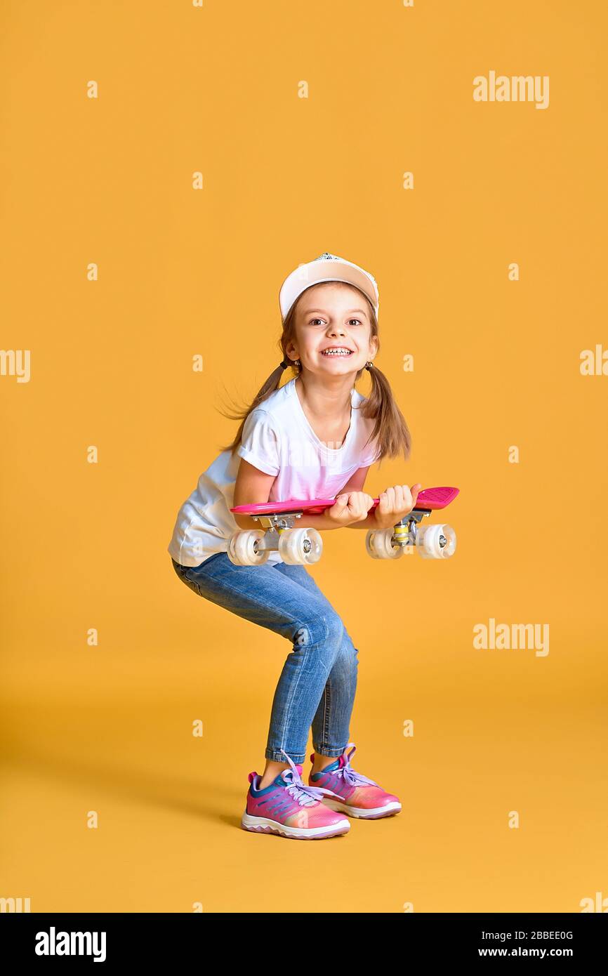 Stylish funny girl wearing white t-shirt, blue jeans and sneakers ...