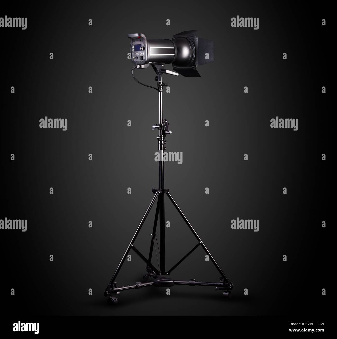 Photography studio flash on a lighting stand isolated on black ...