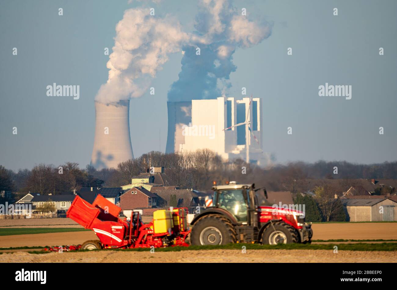 Tractor working a field in spring, potato planting machine, sowing ...