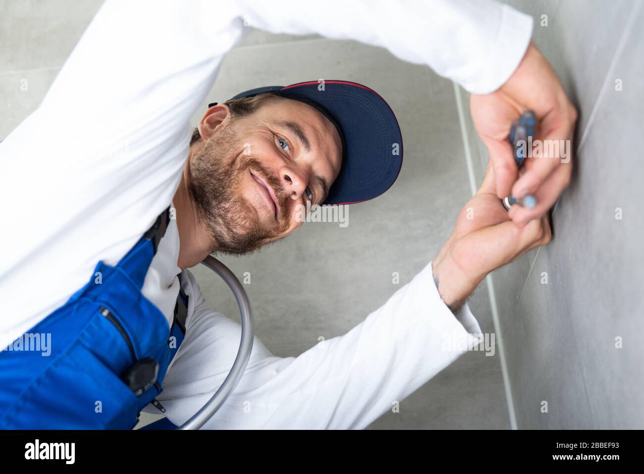 Installer with a pipe wrench at work Stock Photo - Alamy