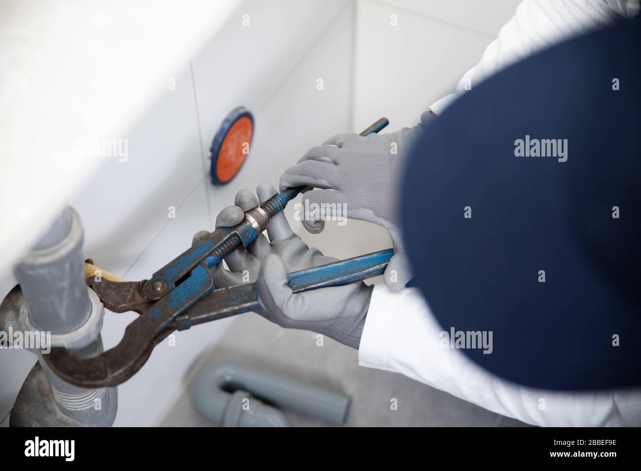 Installer with a pipe wrench at work Stock Photo - Alamy