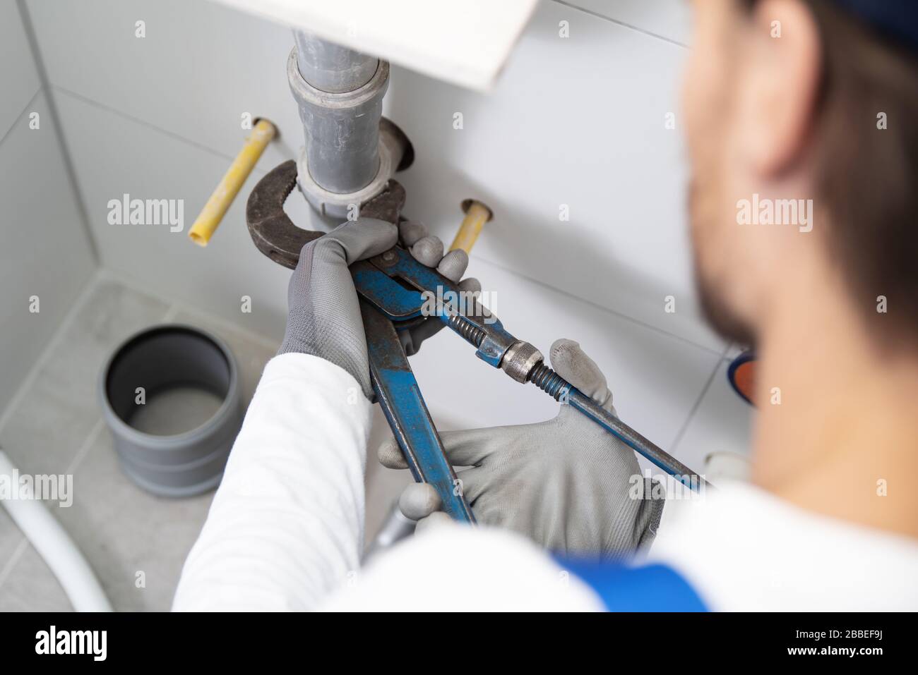 Installer with a pipe wrench at work Stock Photo - Alamy