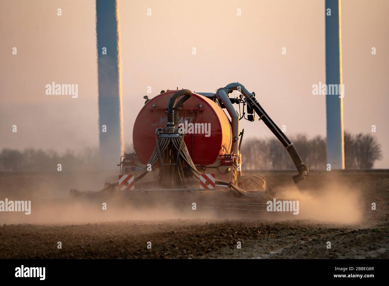 Tractor working a field in spring, transfer of fermentation residue ...