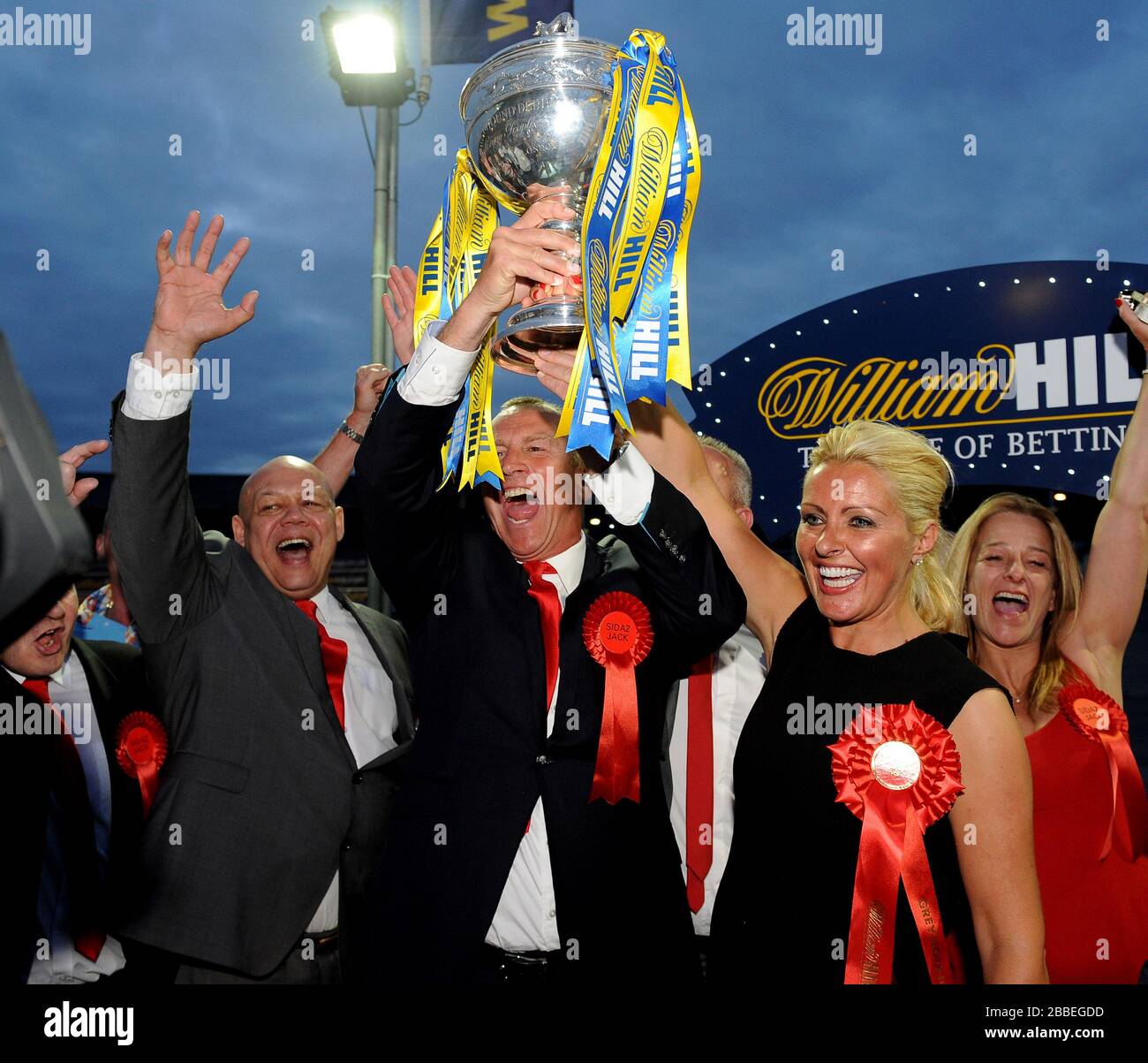 Co-Owner, Simon Wooder (centre) lifts the William Hill Derby trophy ...