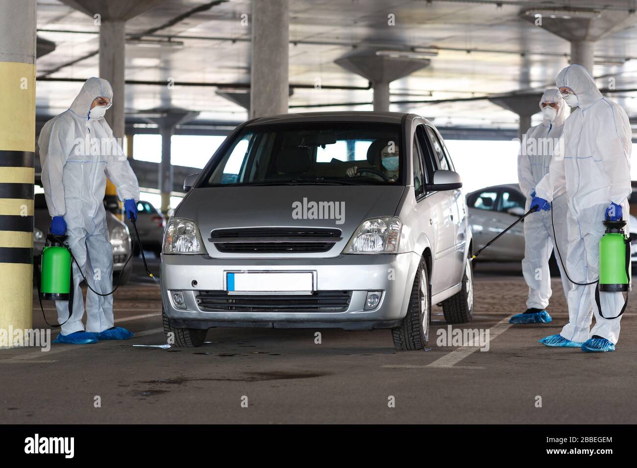 Men in virus protective suits disinfectin car with chemicals Stock ...