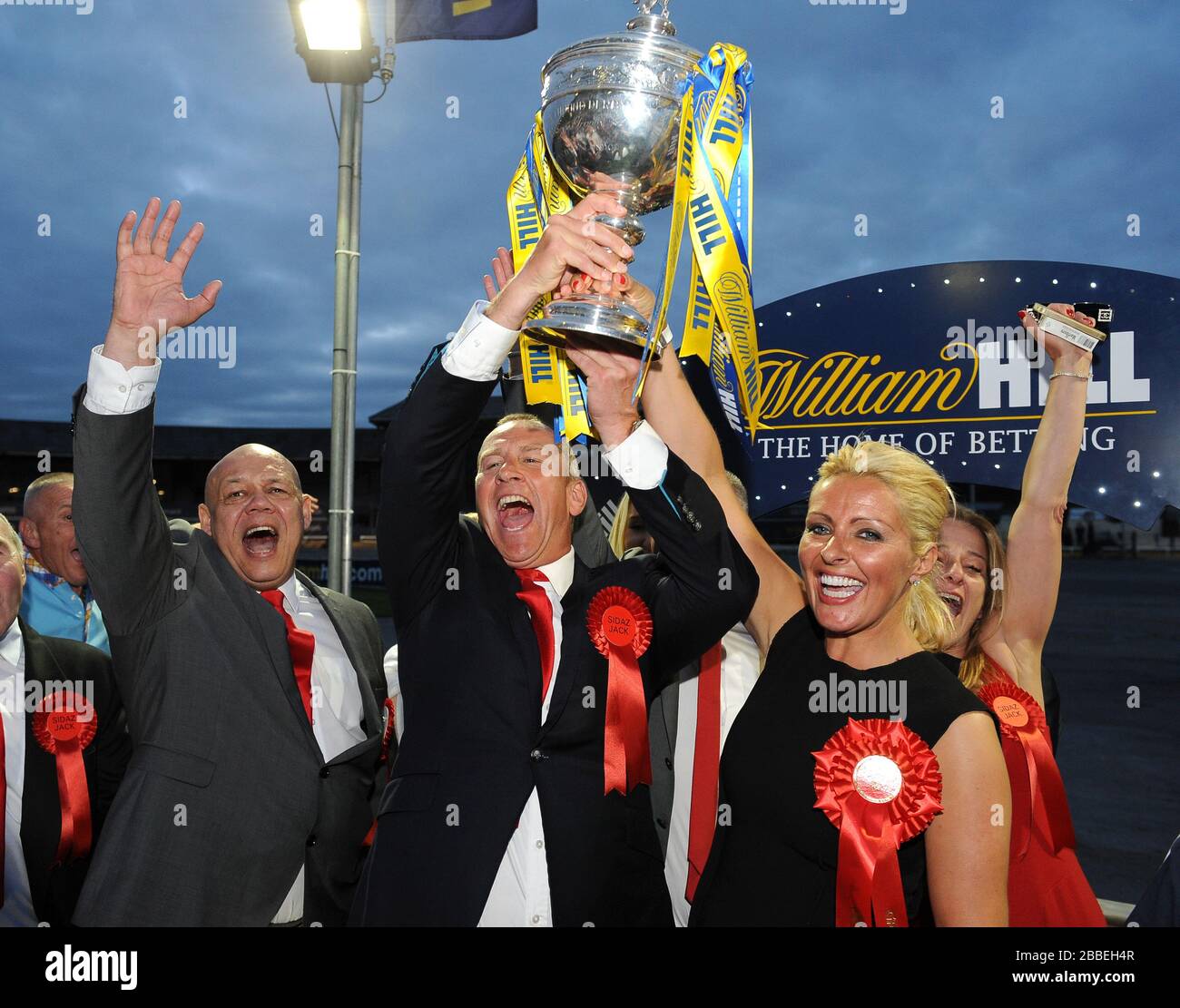 Co-Owner, Simon Wooder (centre) lifts the William Hill Derby trophy ...