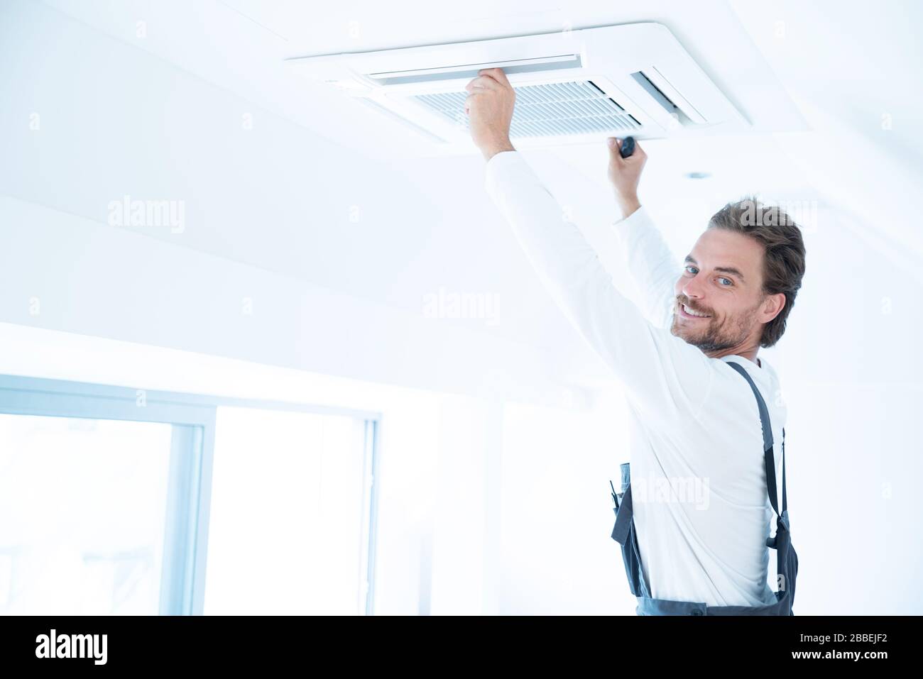 Air conditioning technician works on an air conditioner Stock Photo - Alamy