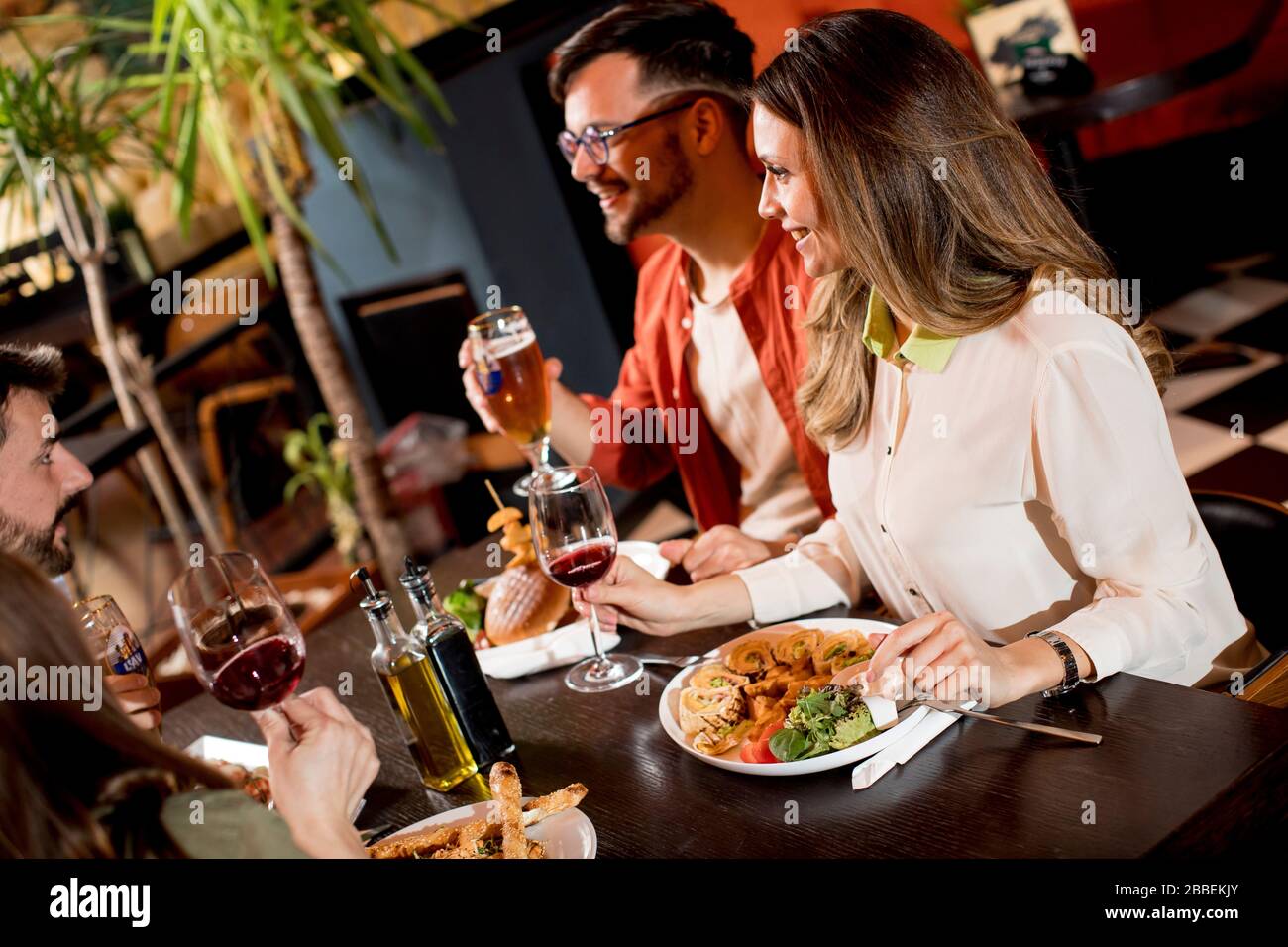 Group of young people having dinner in the restaurant Stock Photo - Alamy