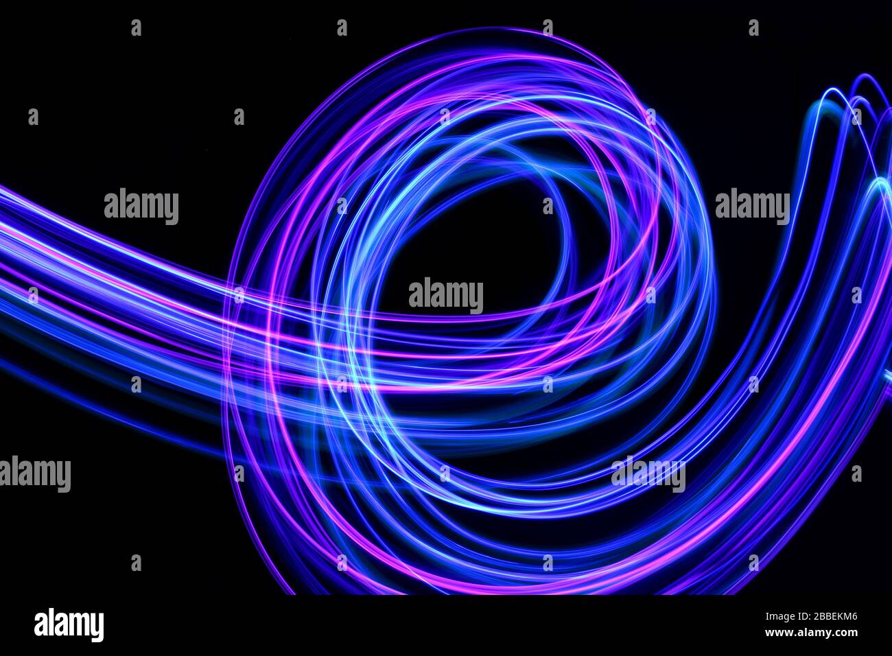 Long exposure photograph of vibrant neon color in an abstract swirl ...