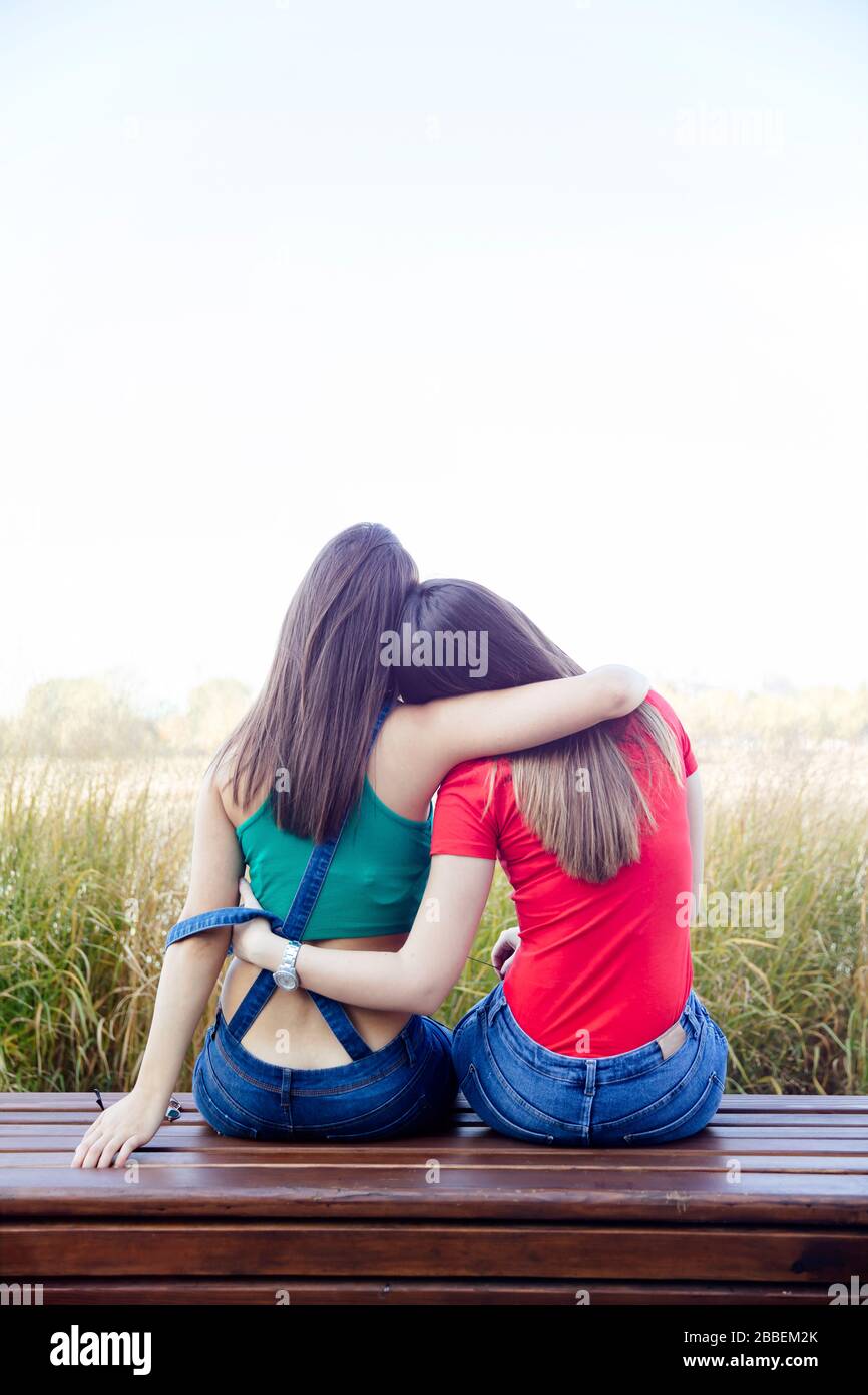 Two best female friends embracing together while sitting outdoors Stock ...