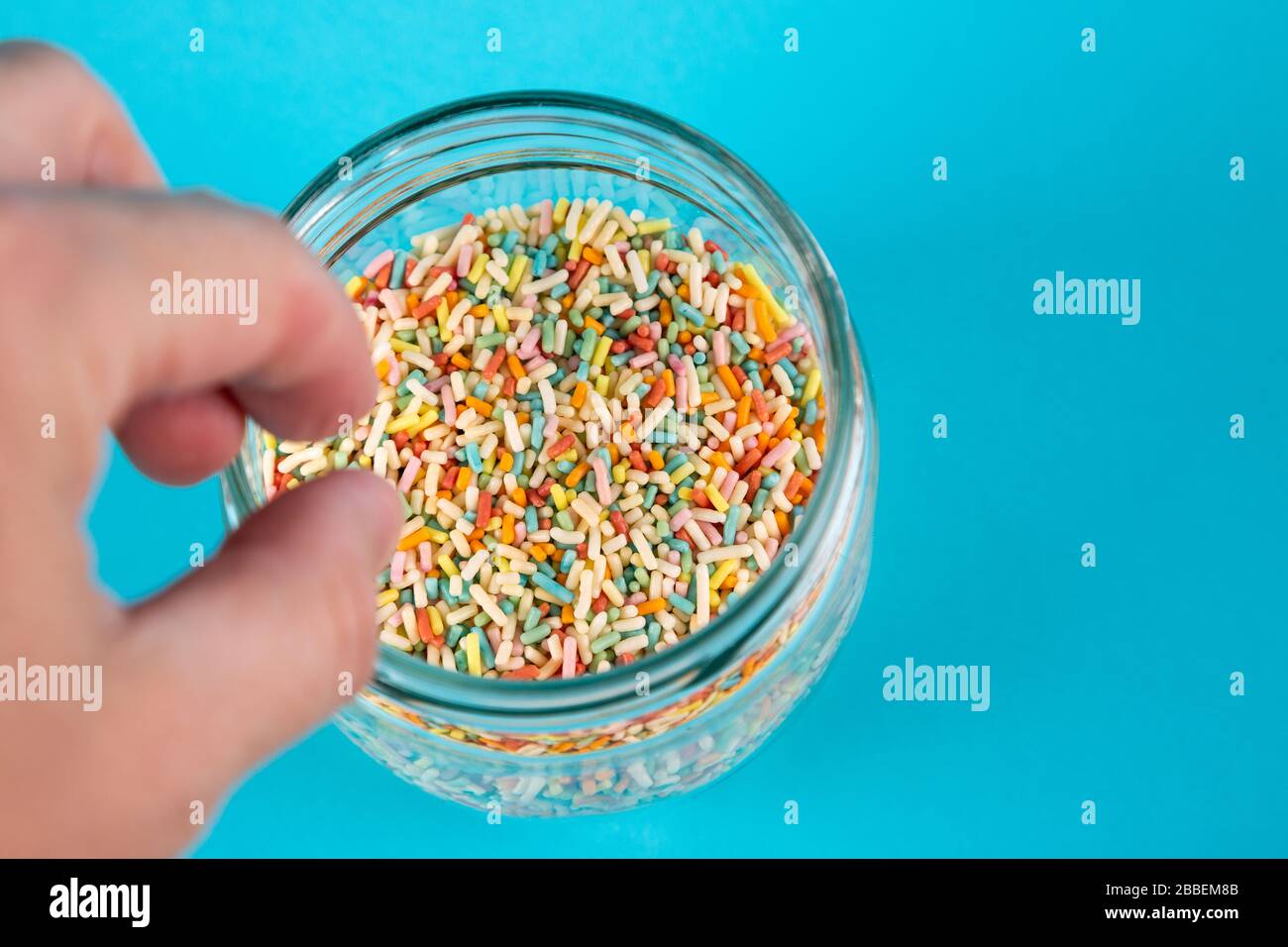 a hand picks up colored sugar sticks Stock Photo - Alamy