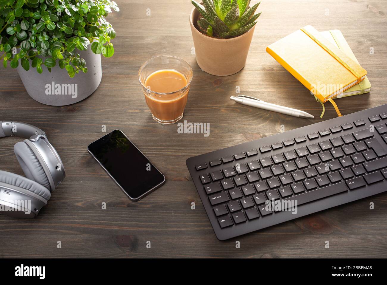 home office desk with keyboard computer smartphone notebook houseplants ...