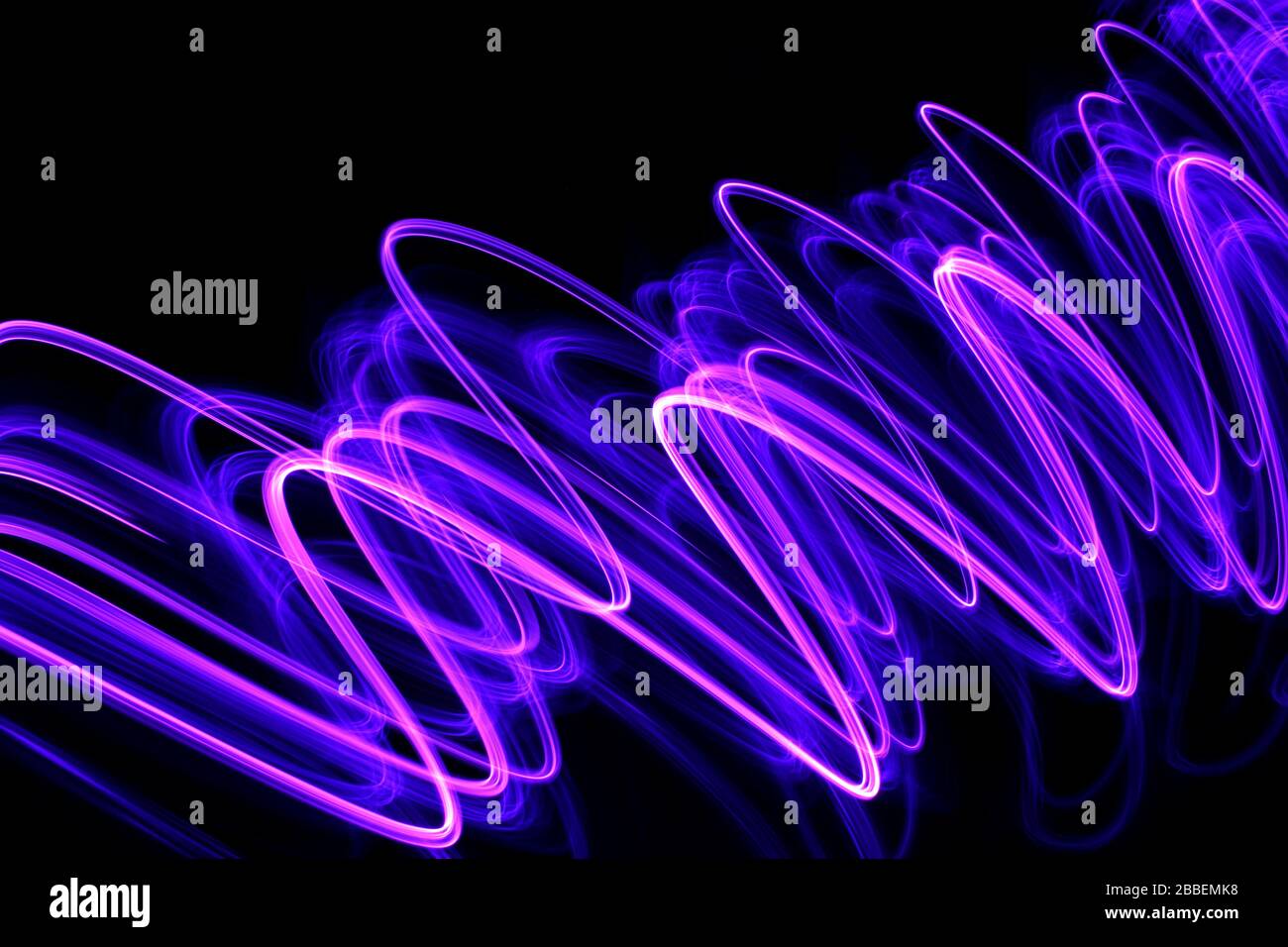 Long exposure photograph of vibrant neon color in an abstract swirl ...