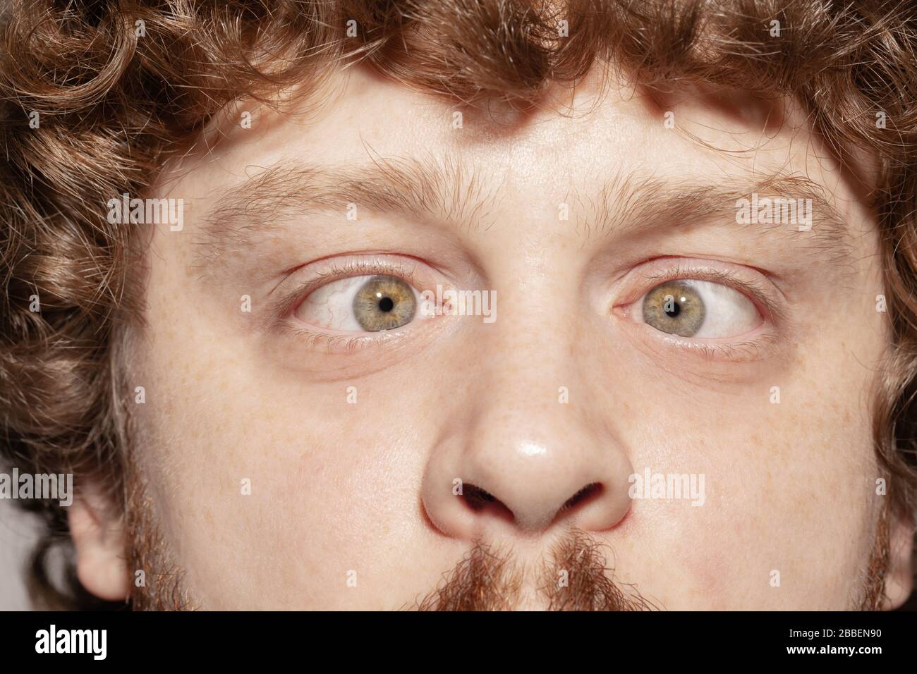 Grimaces. Close up of face of beautiful caucasian young man, focus on ...