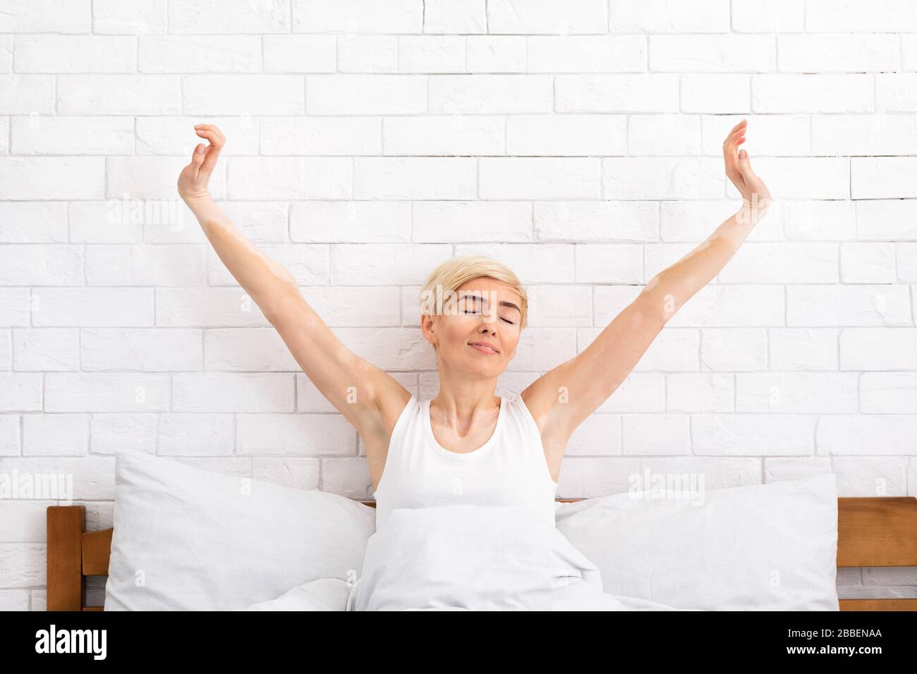 Beautiful middle aged woman waking up in her bed Stock Photo - Alamy
