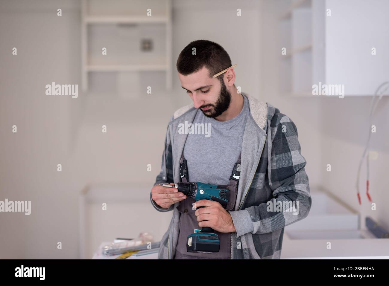 young professional worker preparing a hand drilling machine while ...