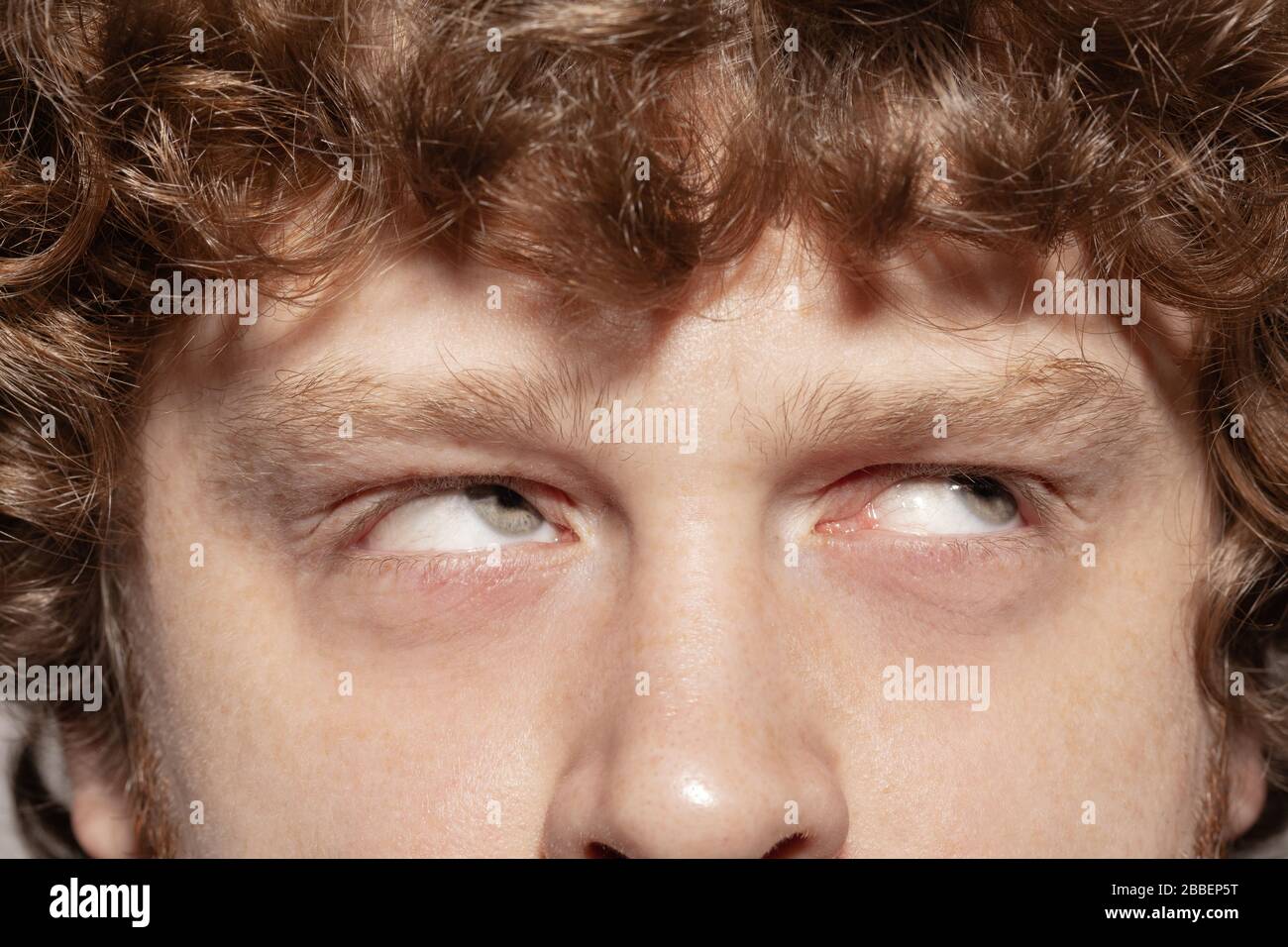 Looking up. Close up of face of beautiful caucasian young man, focus on ...