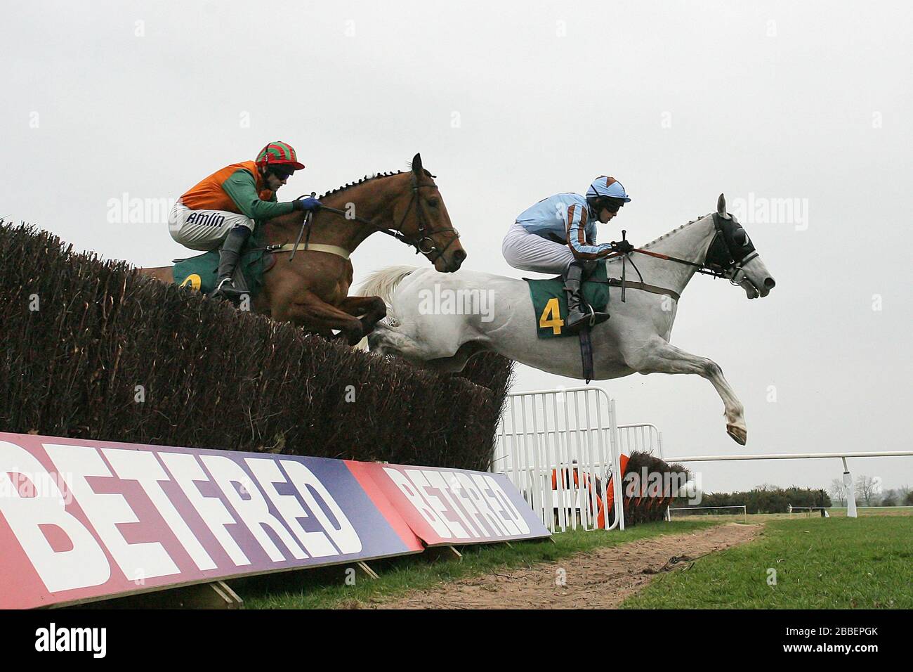 Racer winner Silver Adonis ridden by Mr T Weston (R) jumps alongside ...