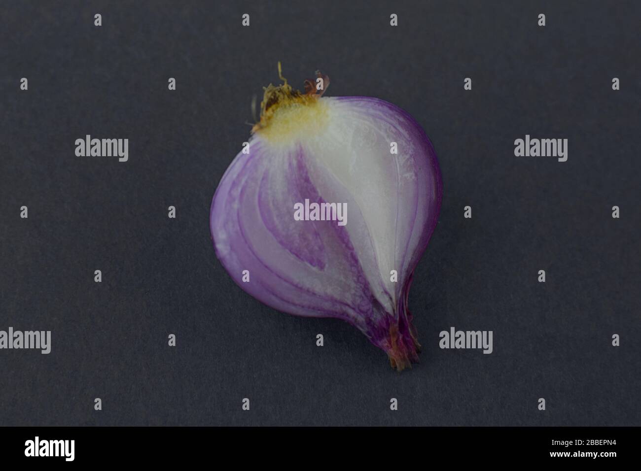 Photograph of a half peeled pink colored onion isolated before an ...