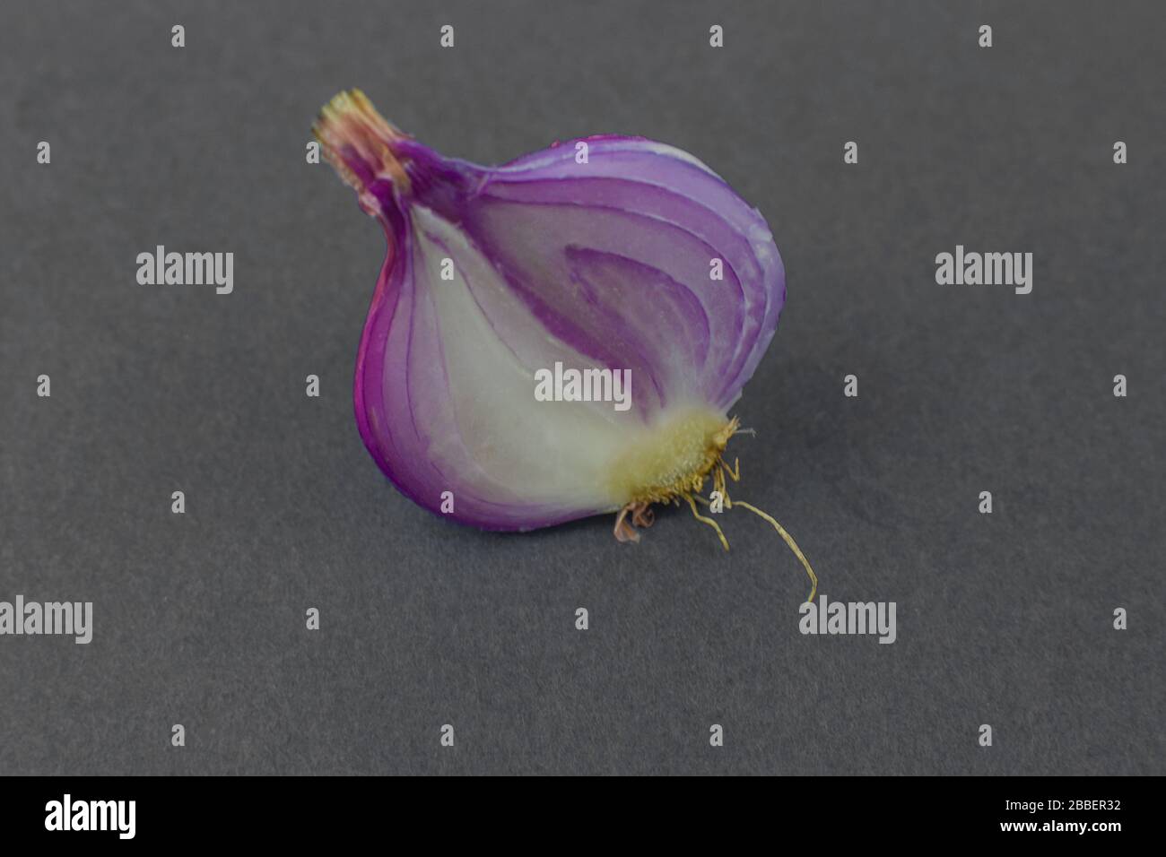 Side view of a half peeled pink colored onion isolated before an ...