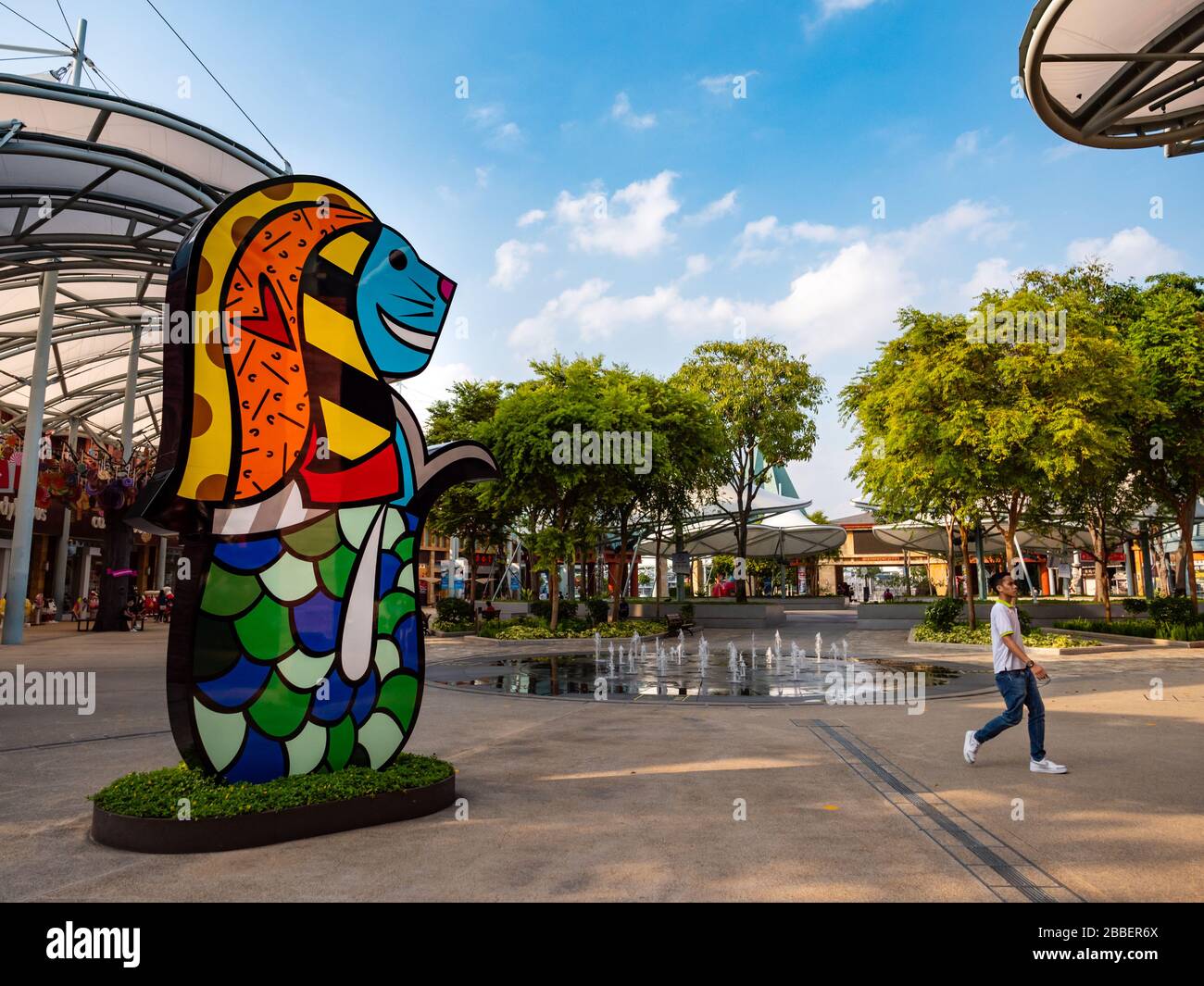 SINGAPORE – 12 MAR 2020 - An Asian man walks past a Merlion statue at ...