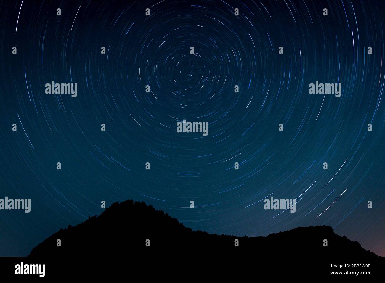 Starry sky with some mountains. Circumpolar star trail Stock Photo - Alamy