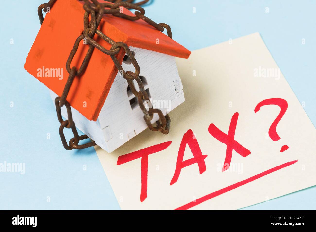 A note with text and a toy house wrapped in a chain, close-up. Real ...