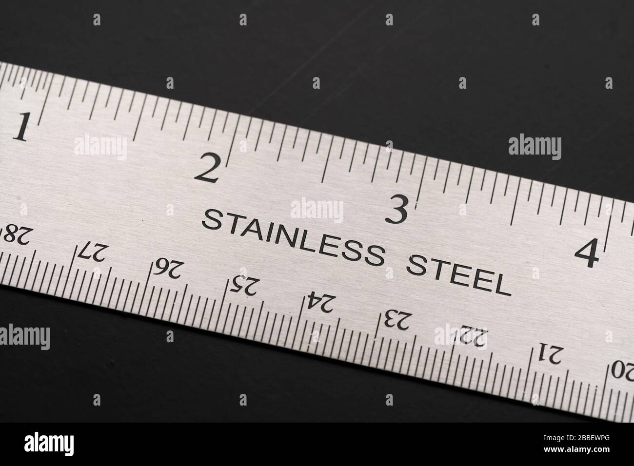 Metal ruler on a black leather isolated background with black numbers ...