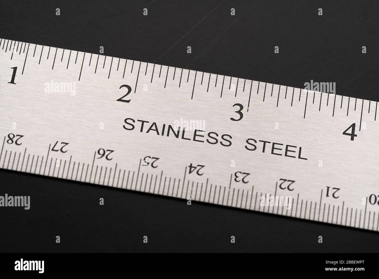 Metal ruler on a black leather isolated background with black numbers ...