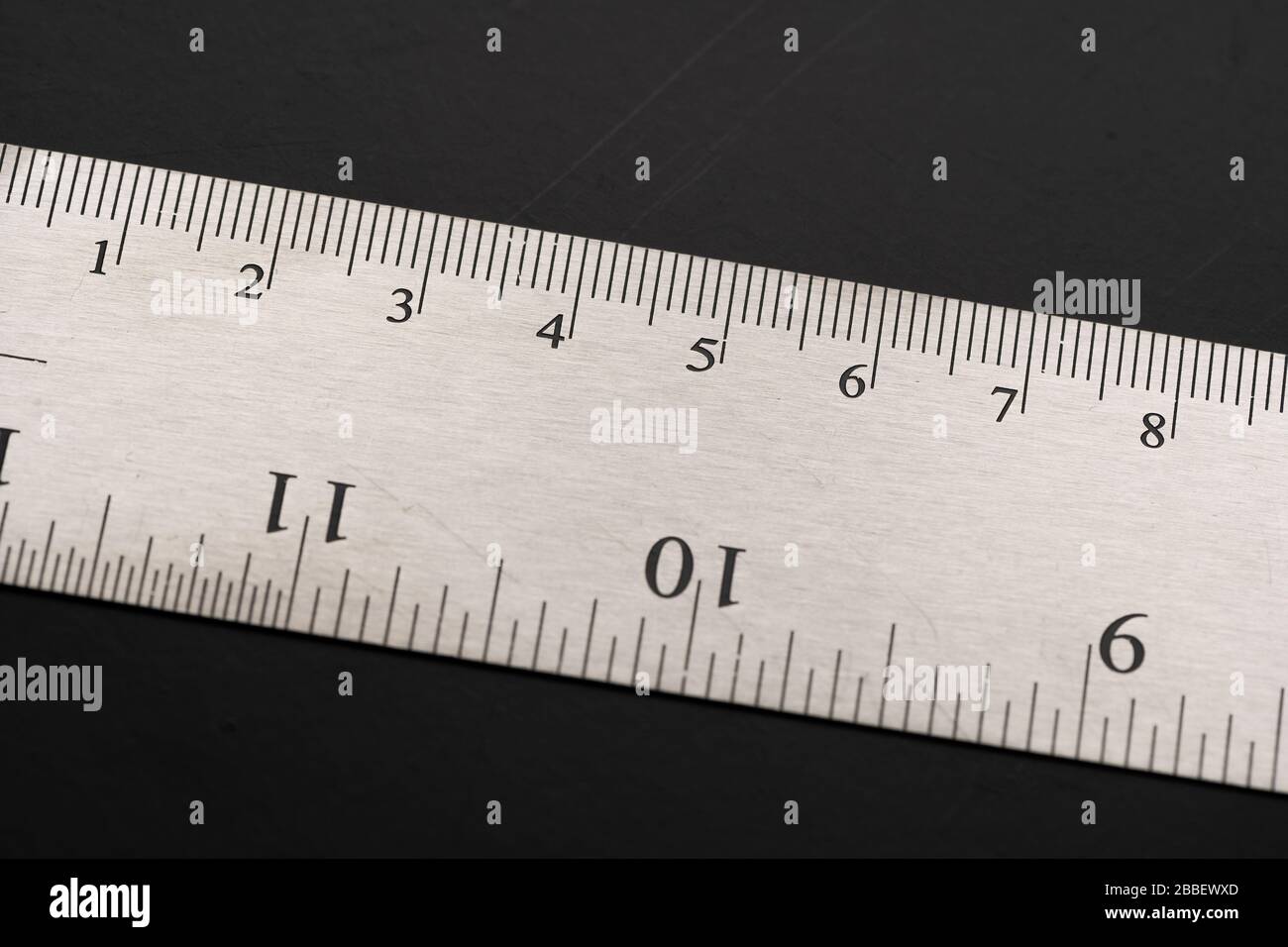 Metal ruler on a black leather isolated background with black numbers ...