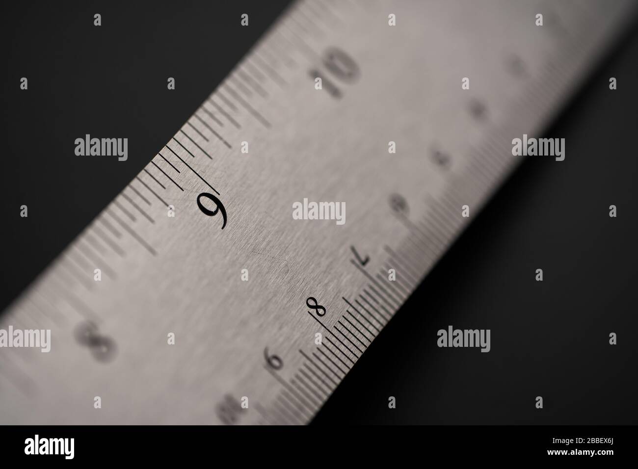 Metal ruler on a black leather isolated background with black numbers ...