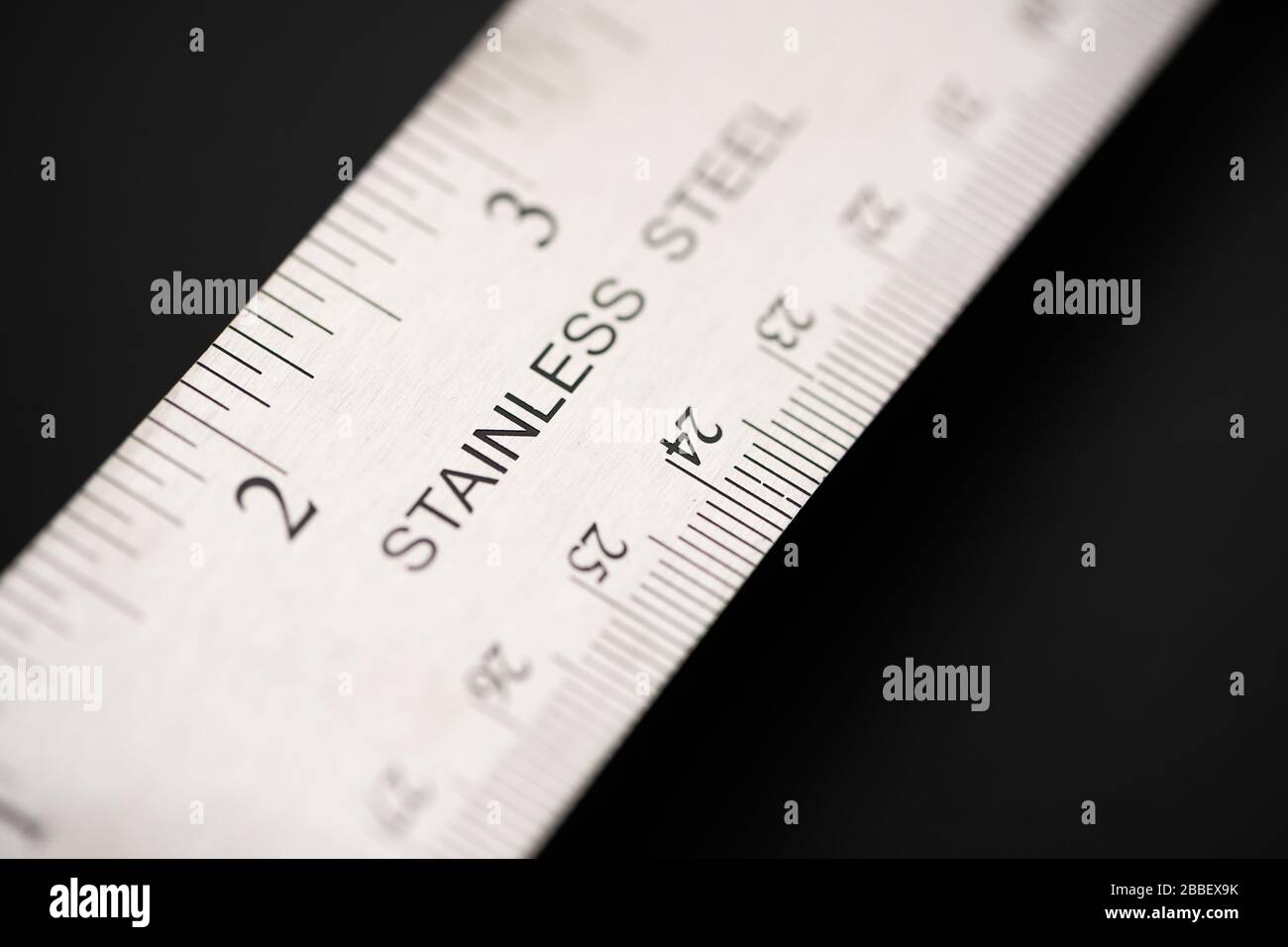 Metal ruler on a black leather isolated background with black numbers ...