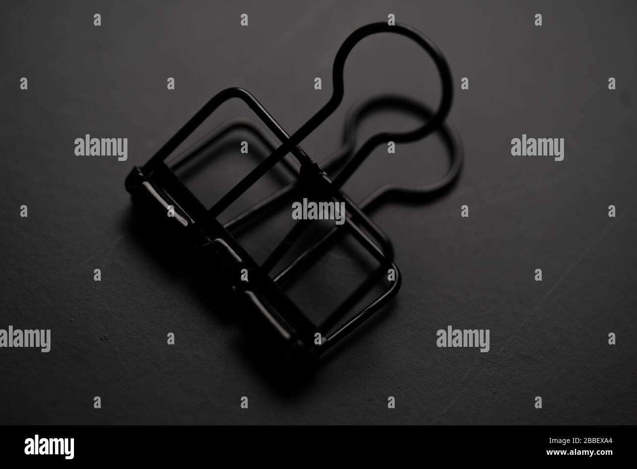 Black paper clip on black background Stock Photo - Alamy