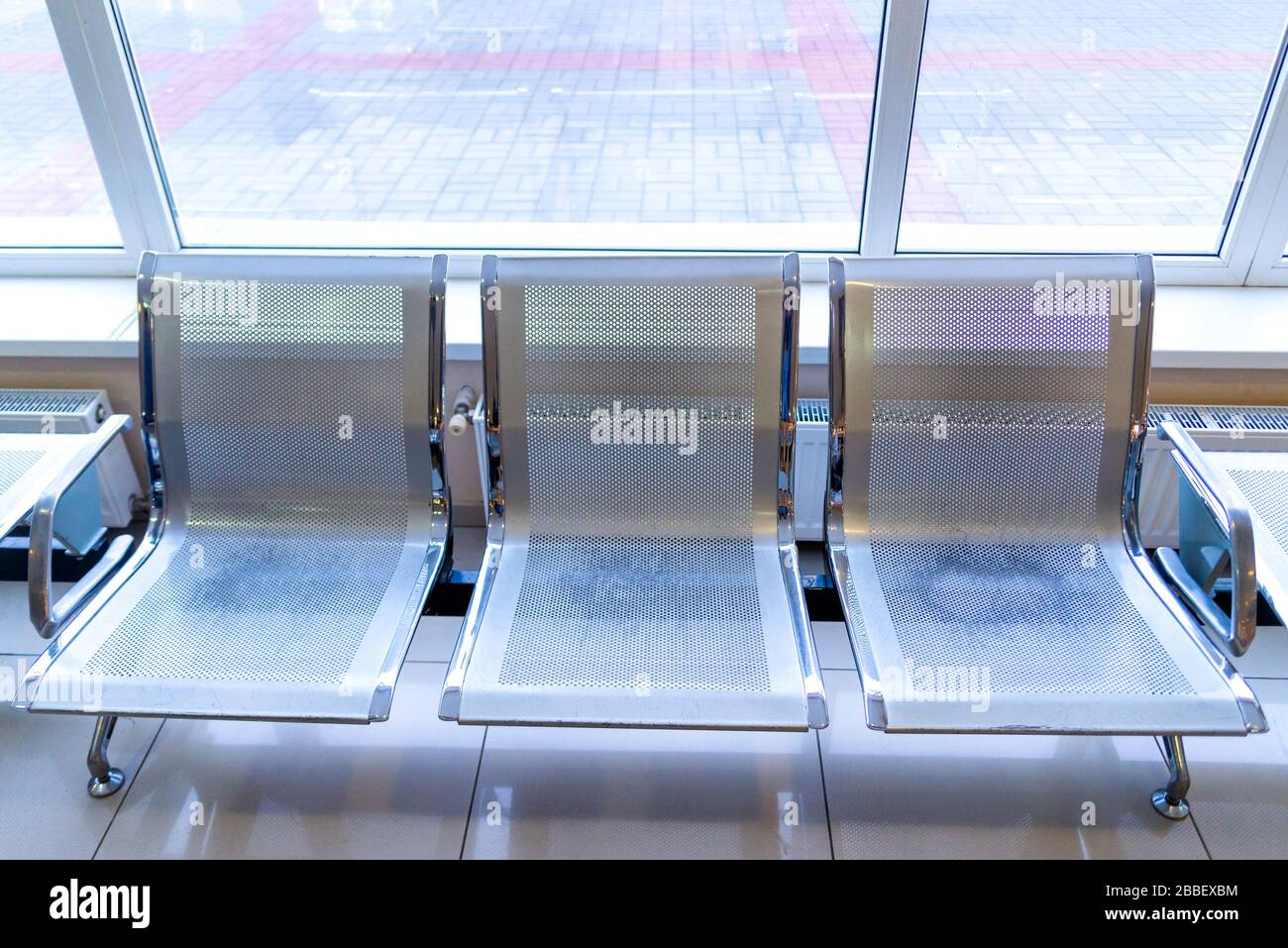 Airport gate waiting area with metal seats Stock Photo - Alamy