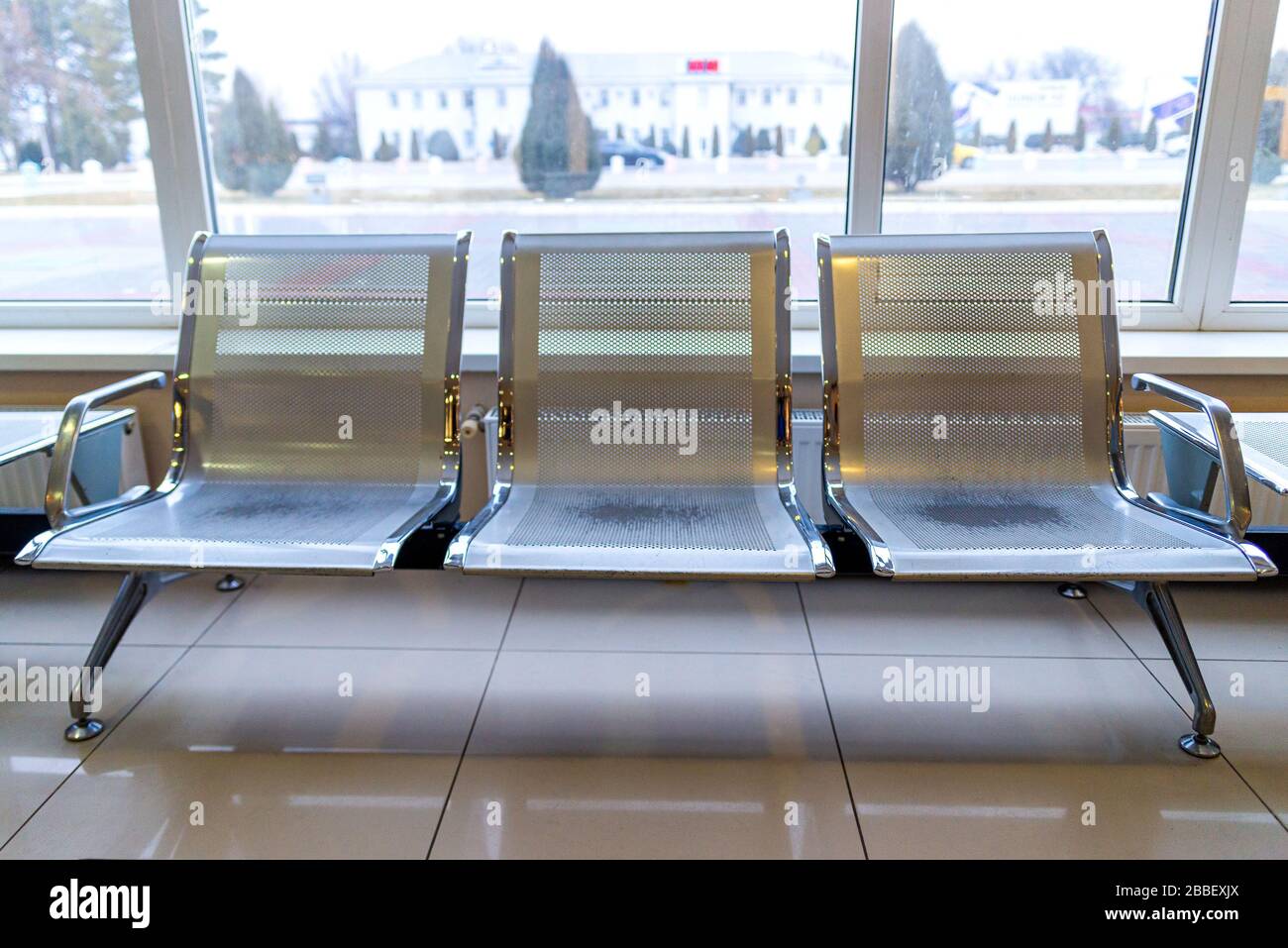 Airport gate waiting area with metal seats Stock Photo - Alamy