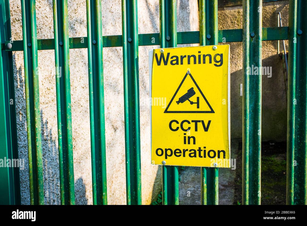 Close up photo of warning sign board on green fence Stock Photo - Alamy