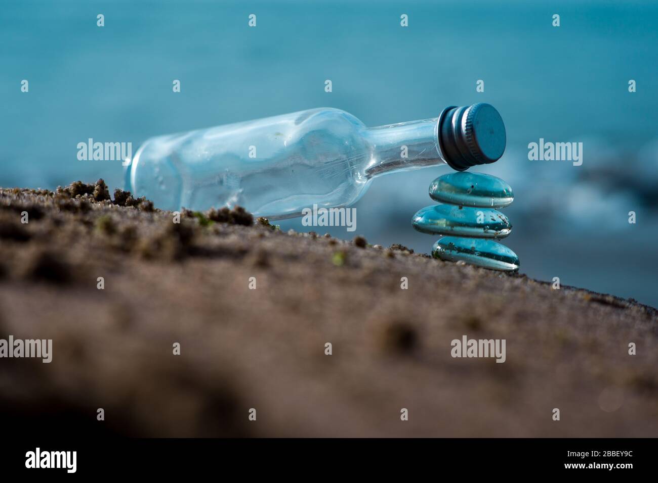 Colorgraded transparent bottle on stack of glass stones symbolizing ...